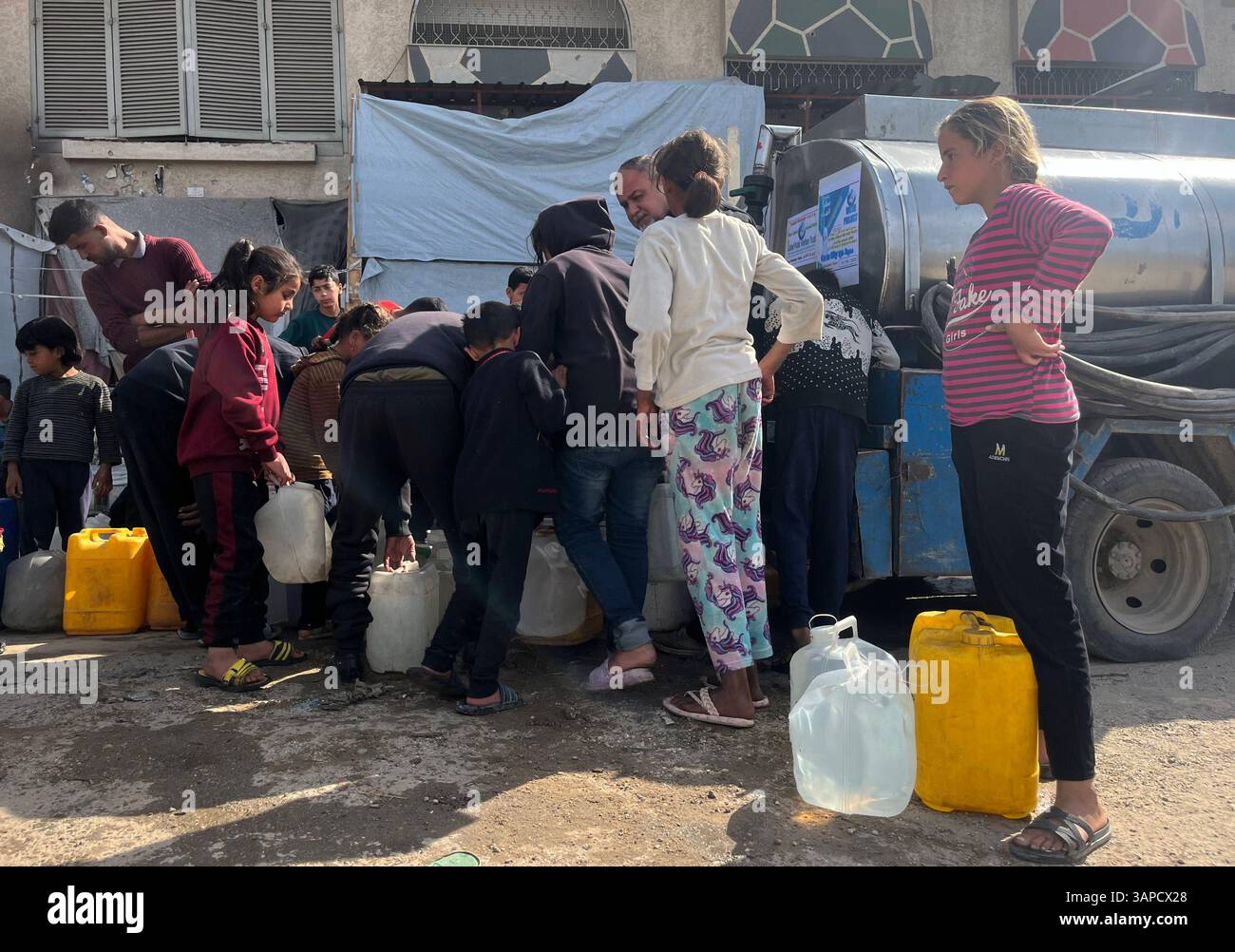 A water tanker distributes clean water to Palestinians in Gaza City A ...