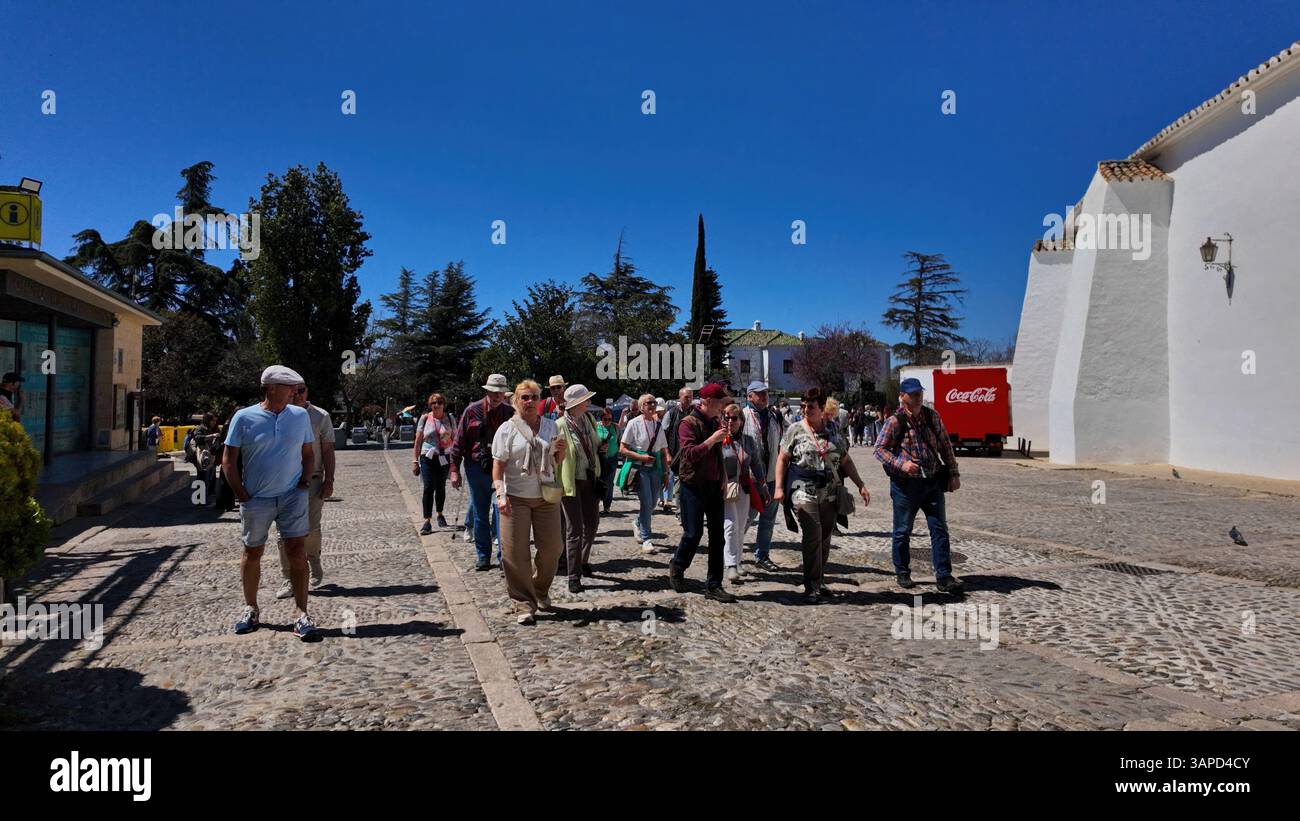 Group of tourists walking in Ronda, Spain, visiting the city center on ...