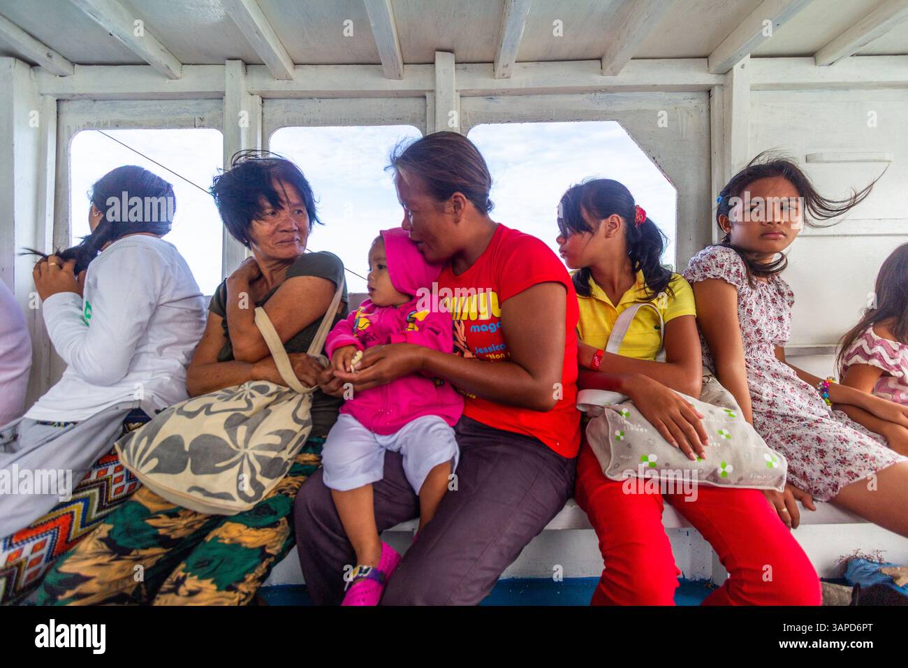 Local Filipino passengers sit inside a motorized boat as it travels ...