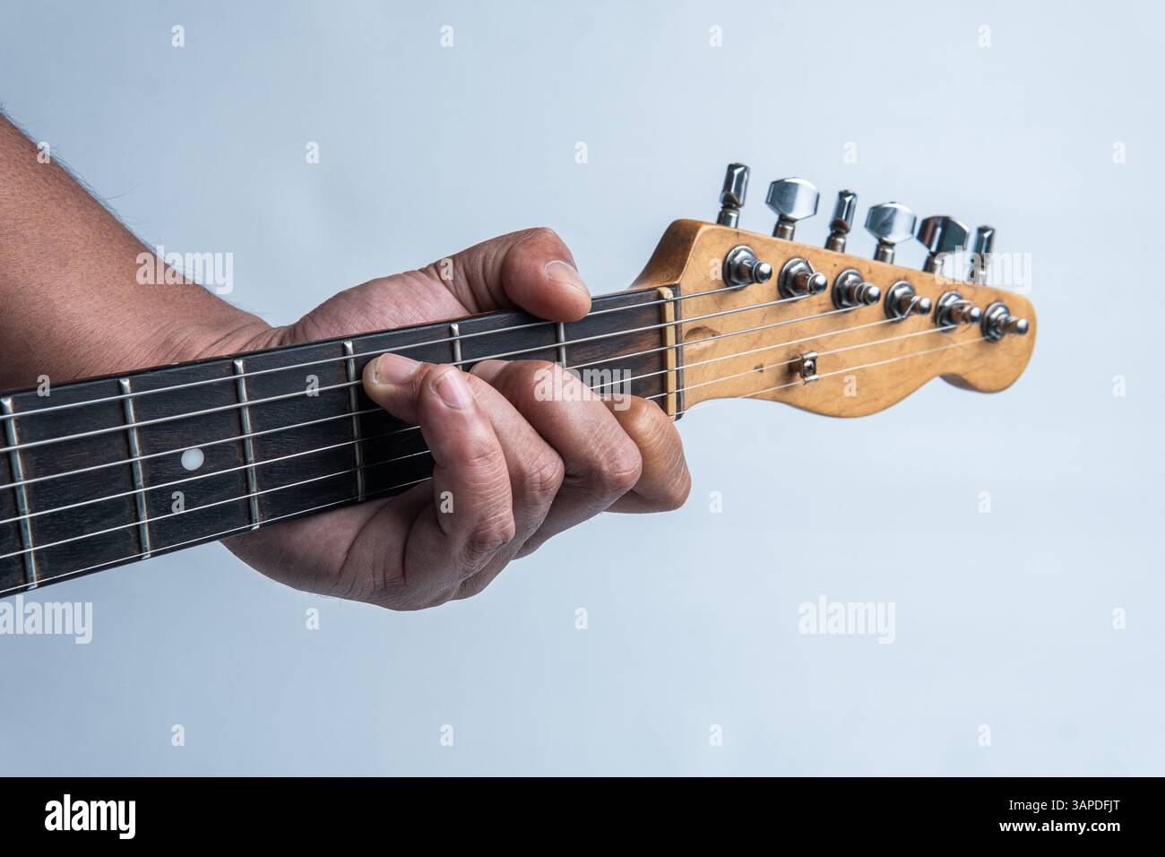 Close-up of a hand forming a C chord on an electric guitar, isolated on ...