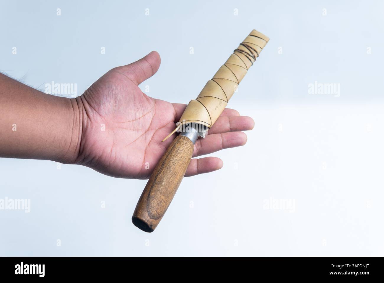 A close-up of a hand holding a traditional knife from Flores, Indonesia ...
