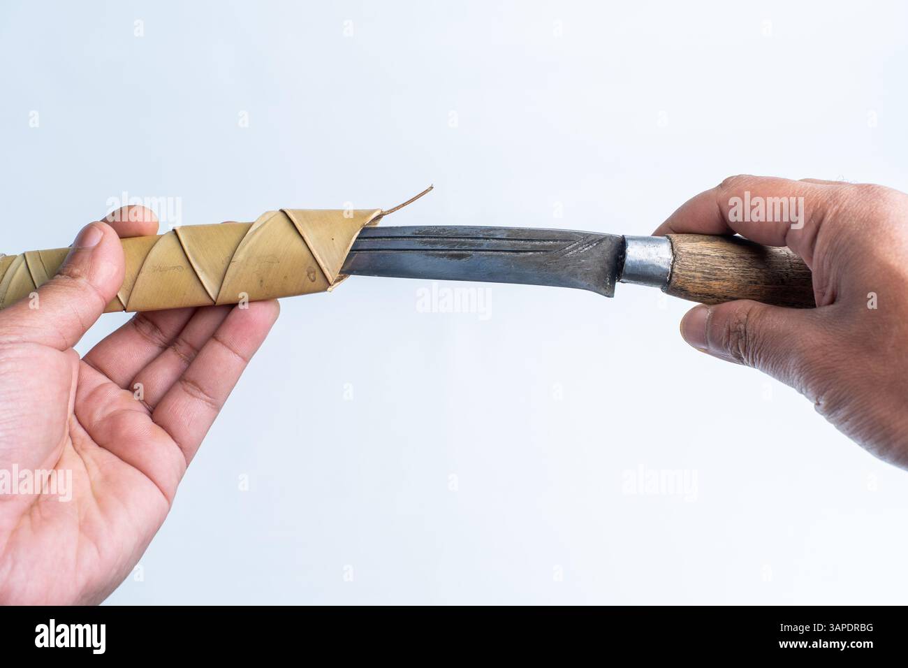 A close-up of a hand holding a traditional knife from Flores, Indonesia ...