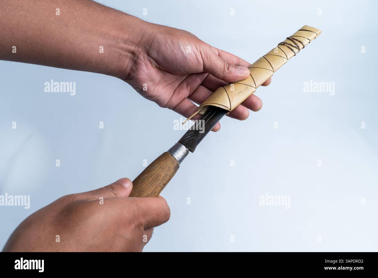 A close-up of a hand holding a traditional knife from Flores, Indonesia ...