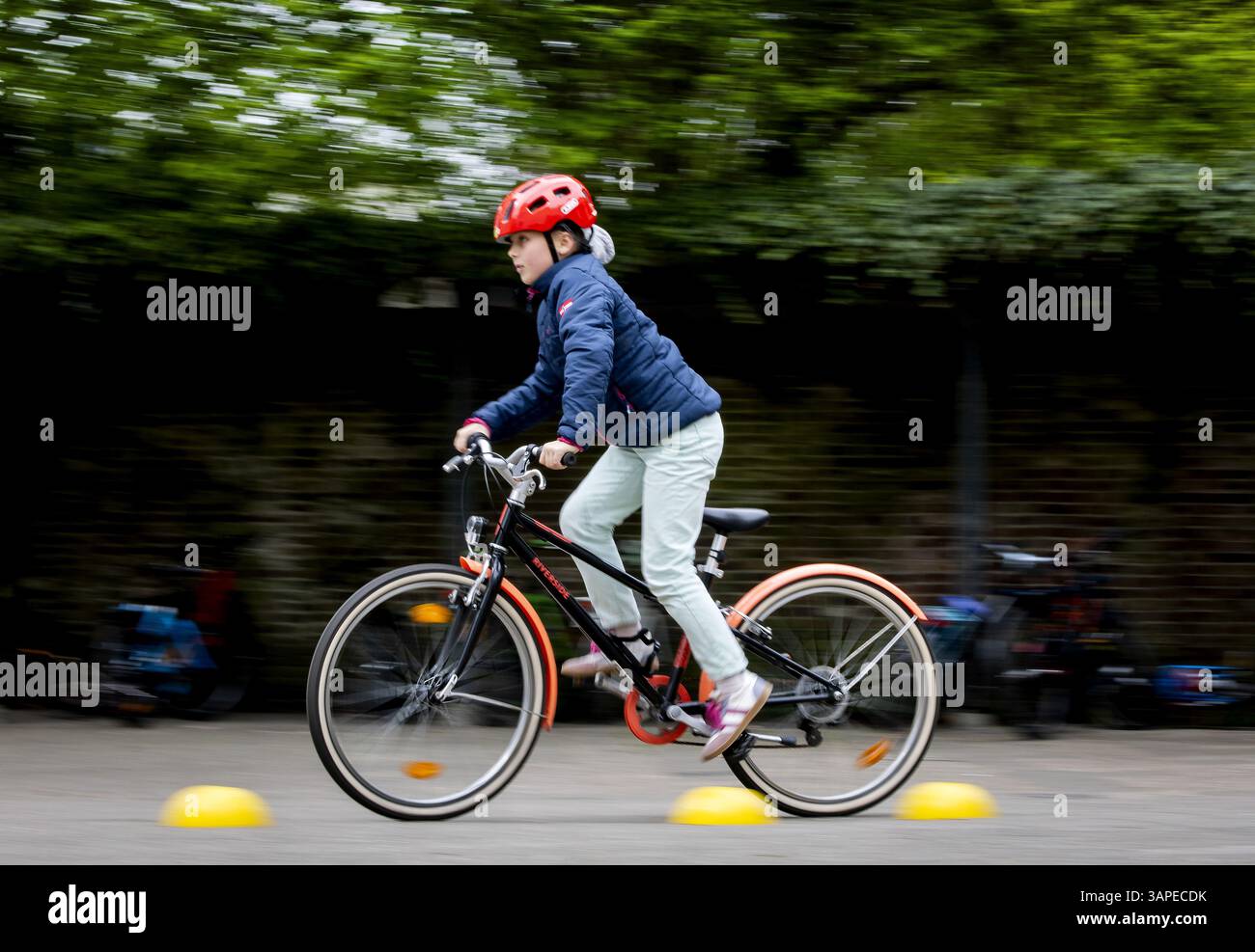 DEN HAAG - Elementary school students ride a bicycle with a bicycle ...