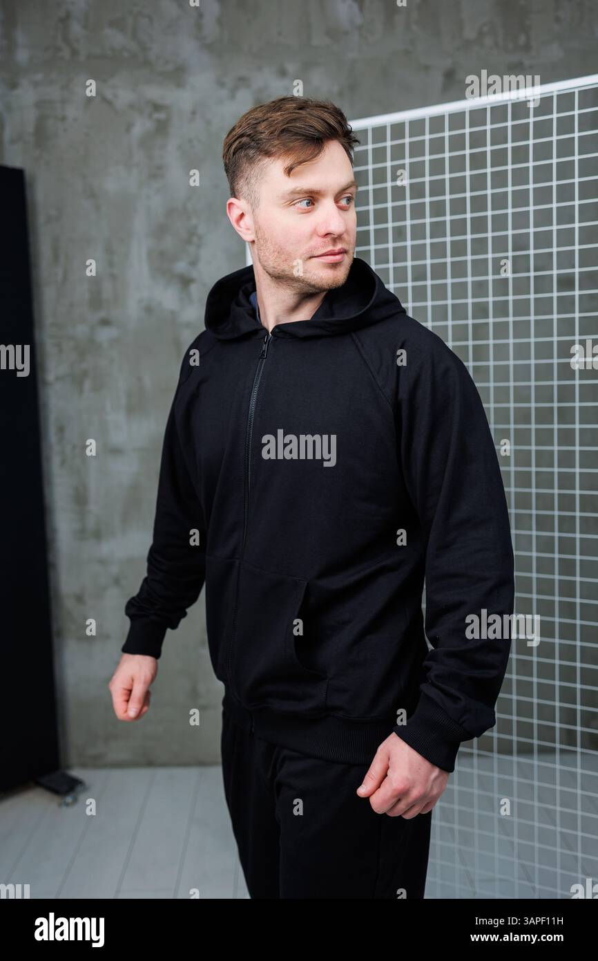 A confident male model poses in a photo studio wearing a stylish black ...