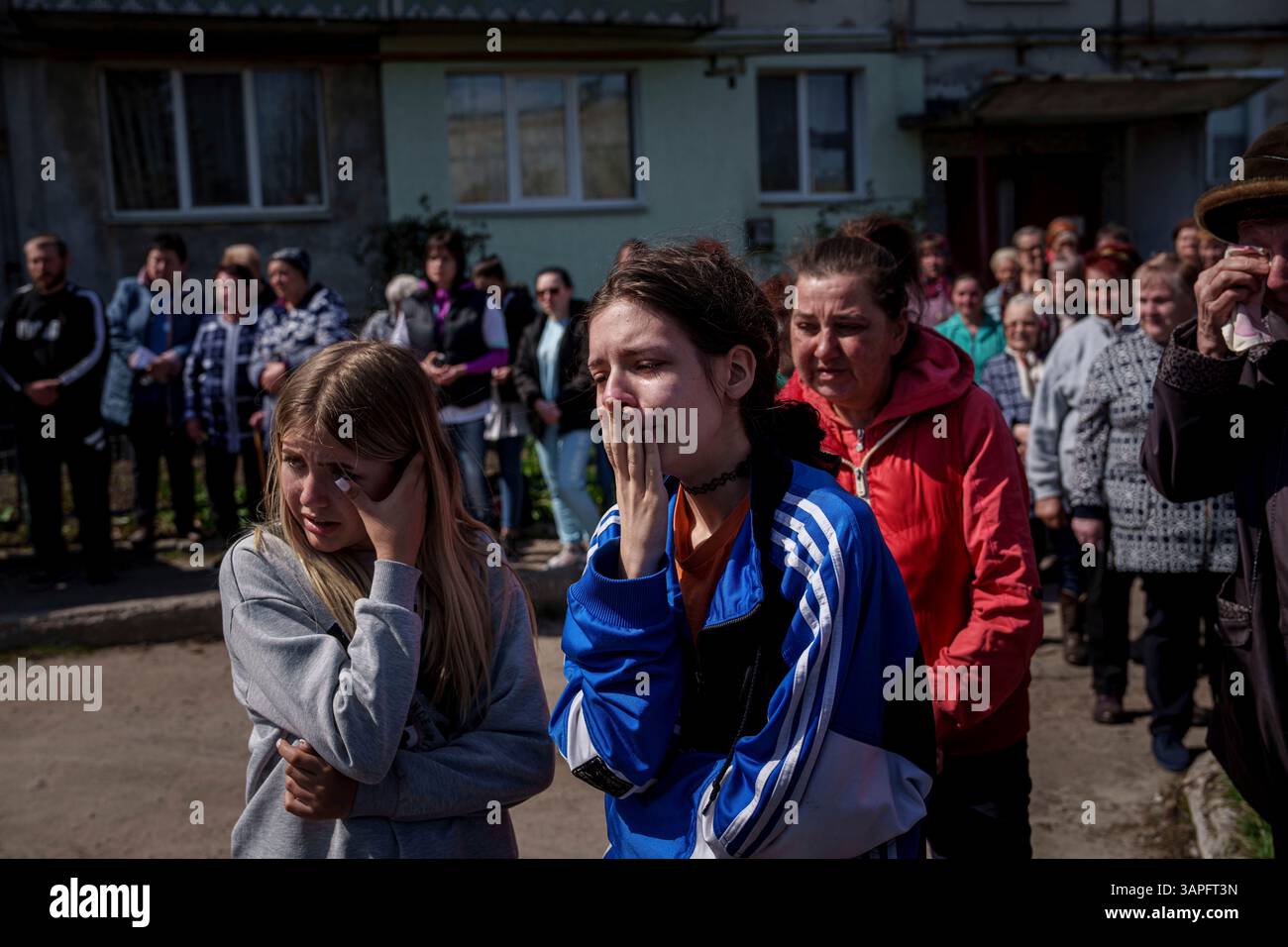 Children cry during a farewell ceremony for Maksym Martynenko, 11, Natalia Martynenko, 49, and ...