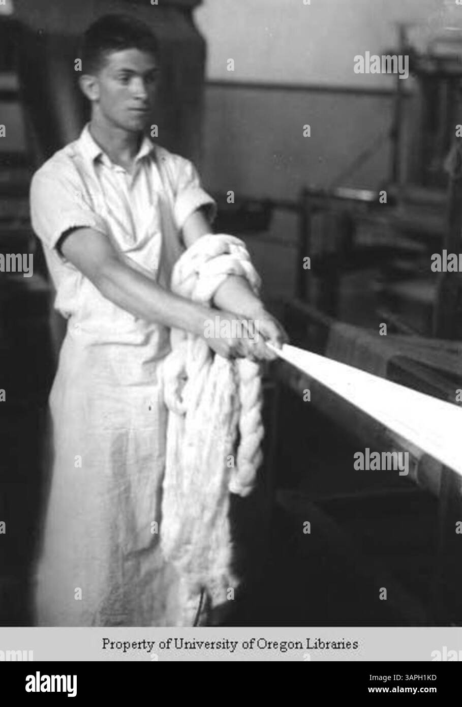 A young man is shown warping a loom as part of the weaving process in a ...
