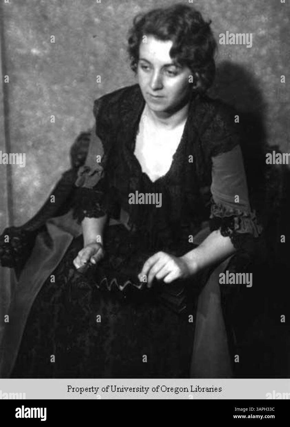 A woman dressed in elegant formal attire, seated in a parlor. The image ...