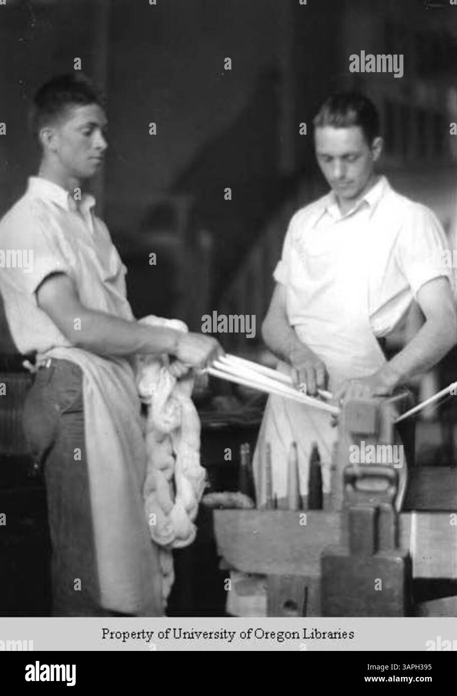 This photograph shows two young men working on warping in a weaving ...