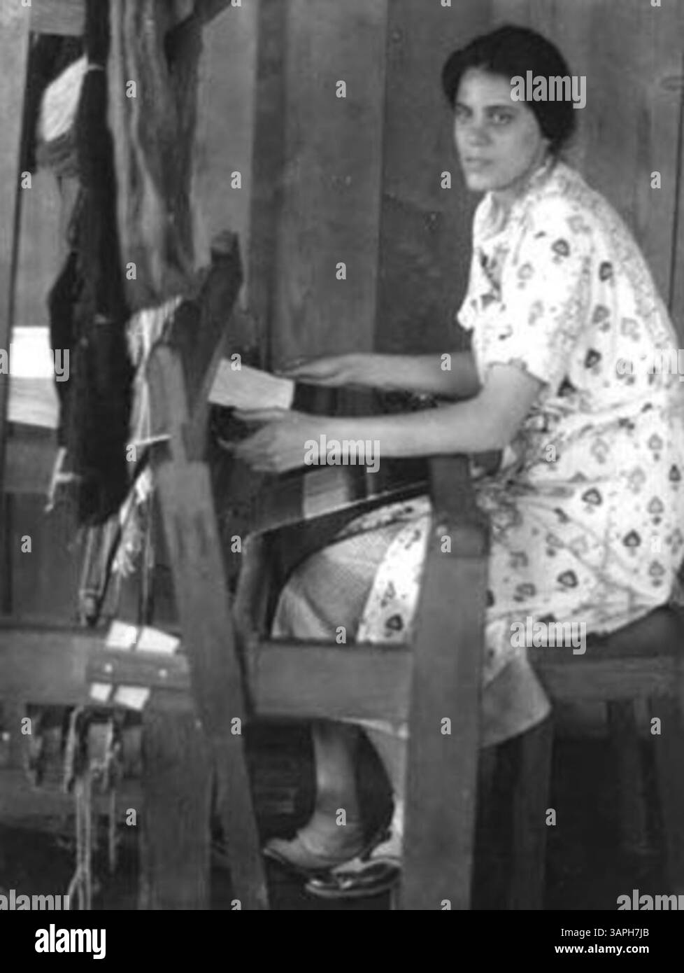 This photograph features Jane Chase, a spinner and weaver, at her loom ...