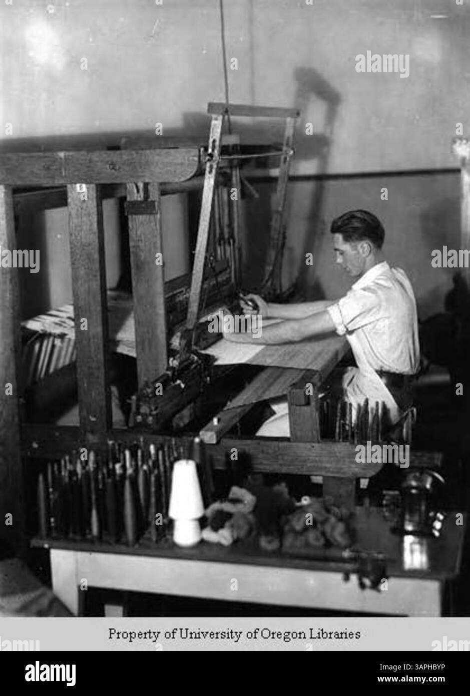 This photograph shows a young man at a loom, engaged in the craft of ...