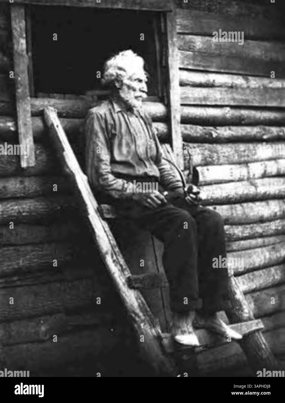 Photograph of an elderly man, Nick Barton, sitting on a ladder to a ...