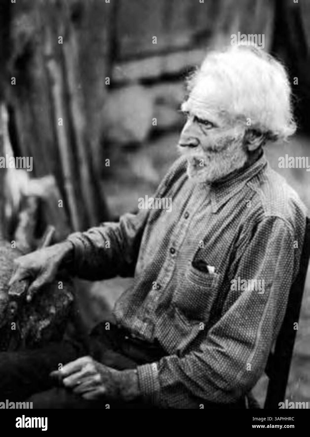 Nick Barton, an elderly man, is photographed holding a hatchet. The ...