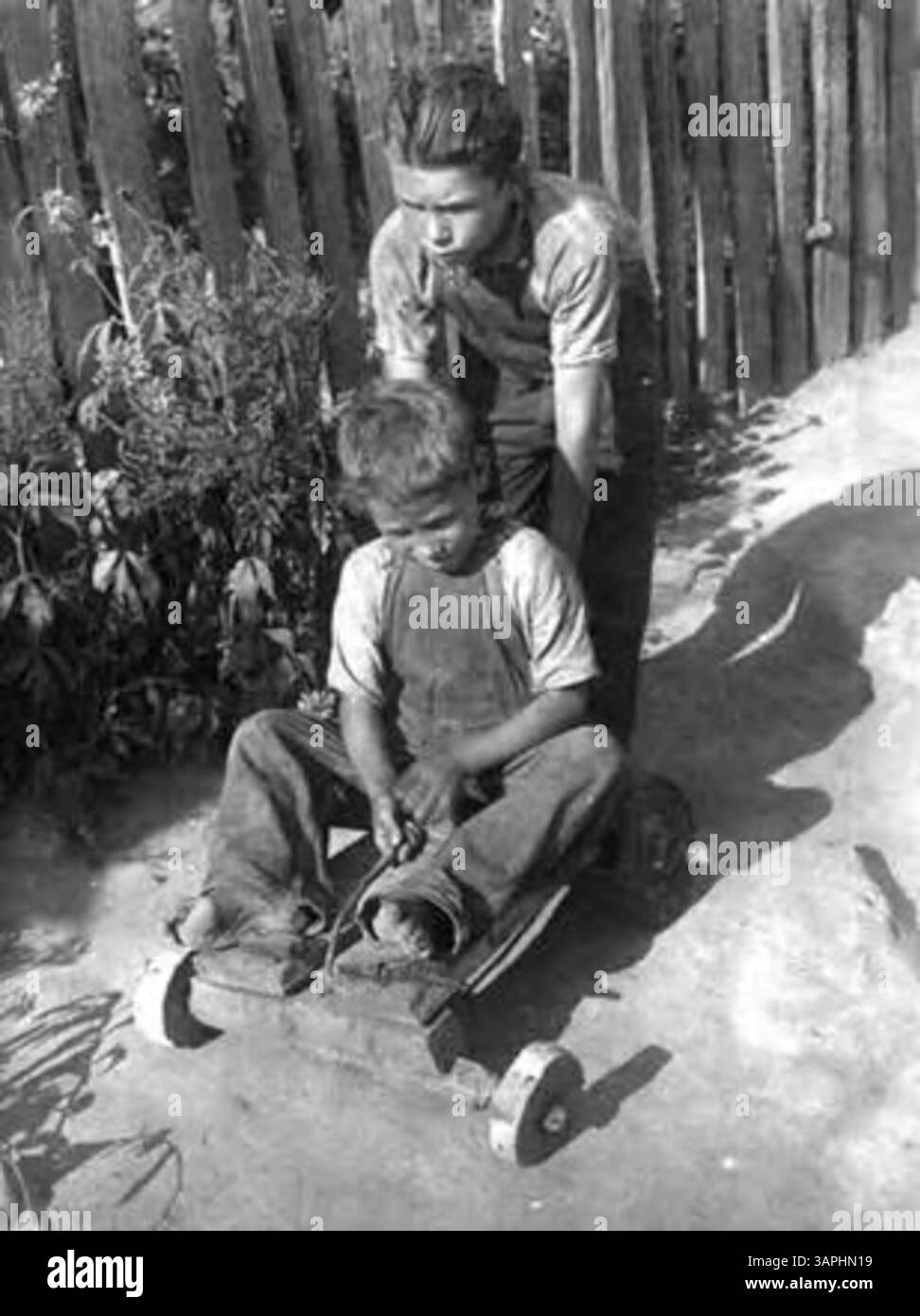 A photograph from the Doris Ulmann collection shows boys riding a cart ...