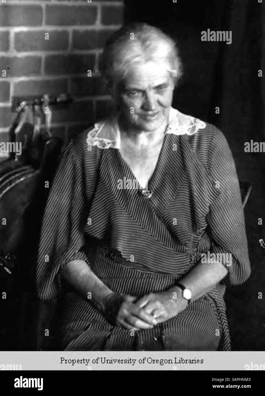 A photograph of Ms. Frost seated, dressed in a striped dress with a ...