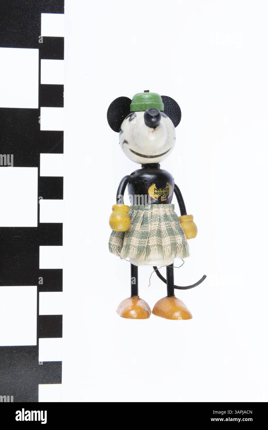 An early wooden Minnie Mouse doll, featuring a green and white skirt ...
