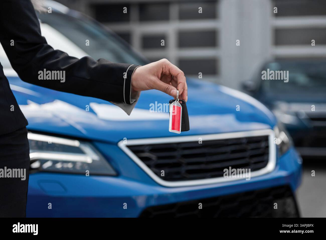 Hand holding car keys, selective focus image. Close-up side view of ...