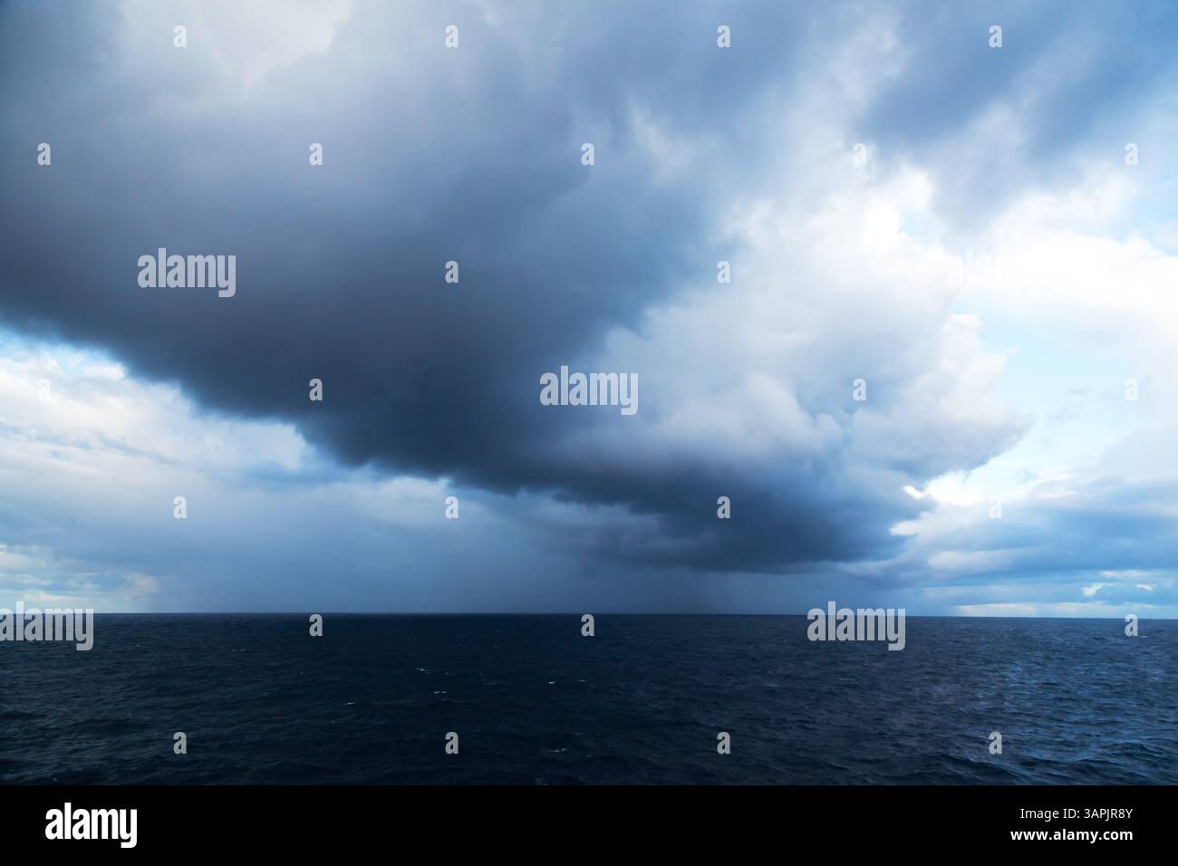 Cloudy sky with rain in the distance in the open sea Stock Photo - Alamy