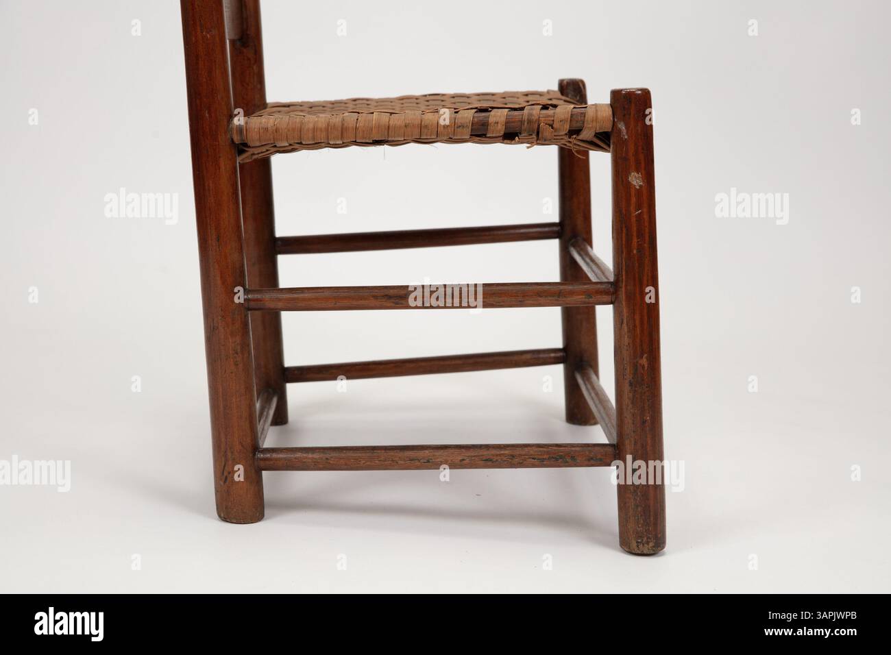 A wooden slat-back side chair made using peg construction. The seat is ...