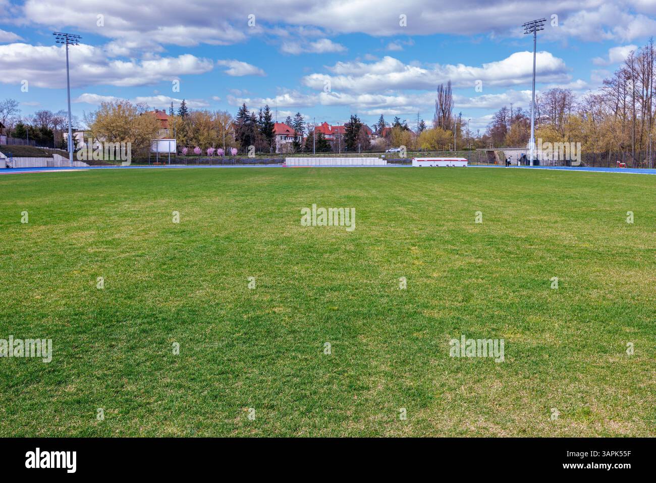 Football field of the city stadium with natural green grass. Blue sky ...