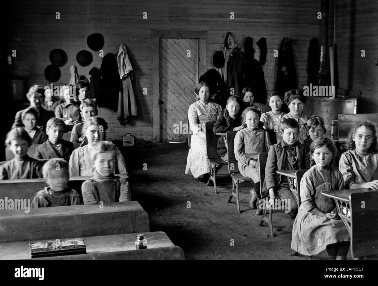 This black-and-white photograph by Roy C. Andrews shows students seated ...