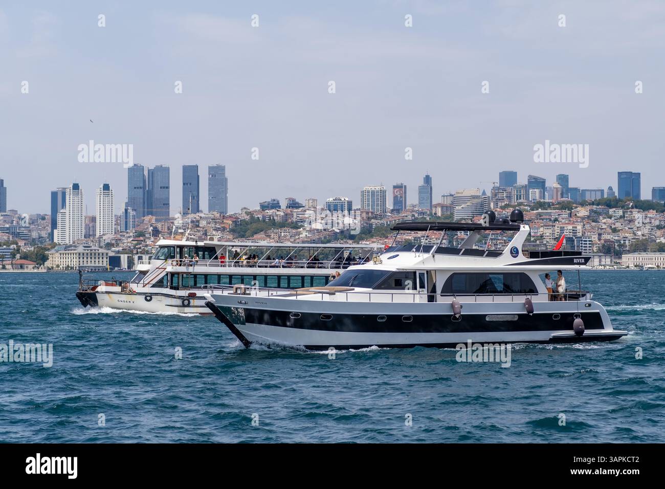 Bosphorus waterfront with modern boats and city skyline under clear sky ...