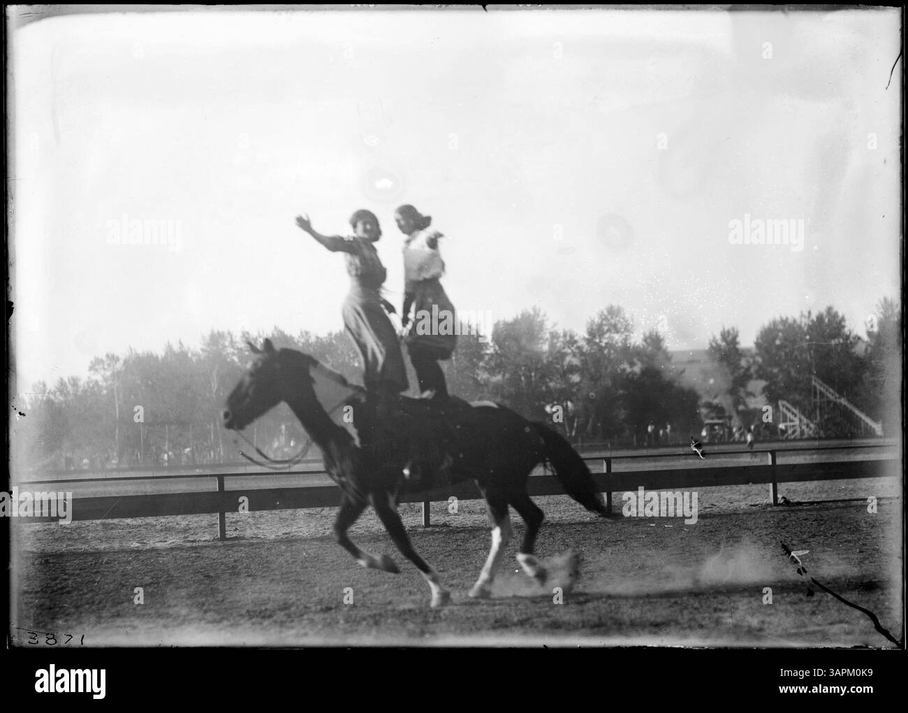 Photograph by Lee Moorhouse of cowgirls performing trick riding. The ...