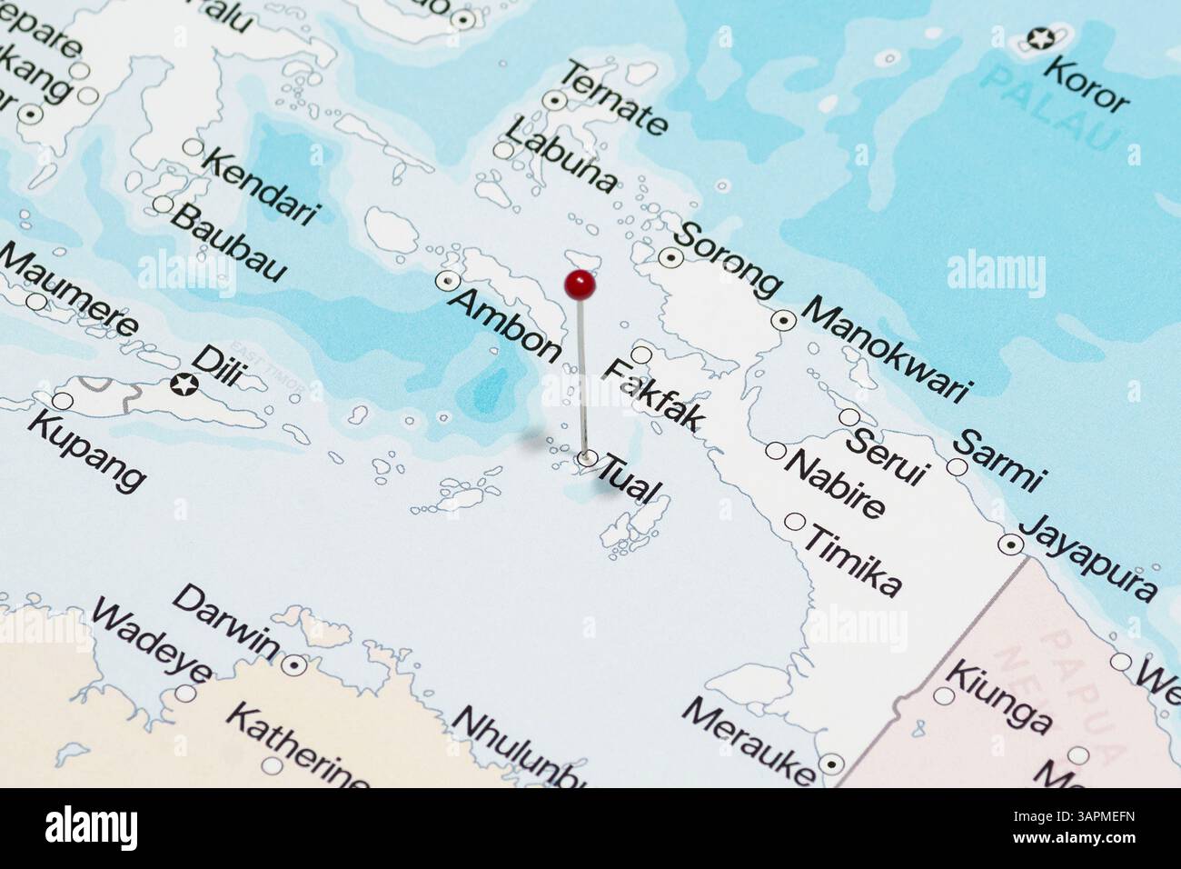 macro photo of a red pin needle into Tual city of Indonesia political ...