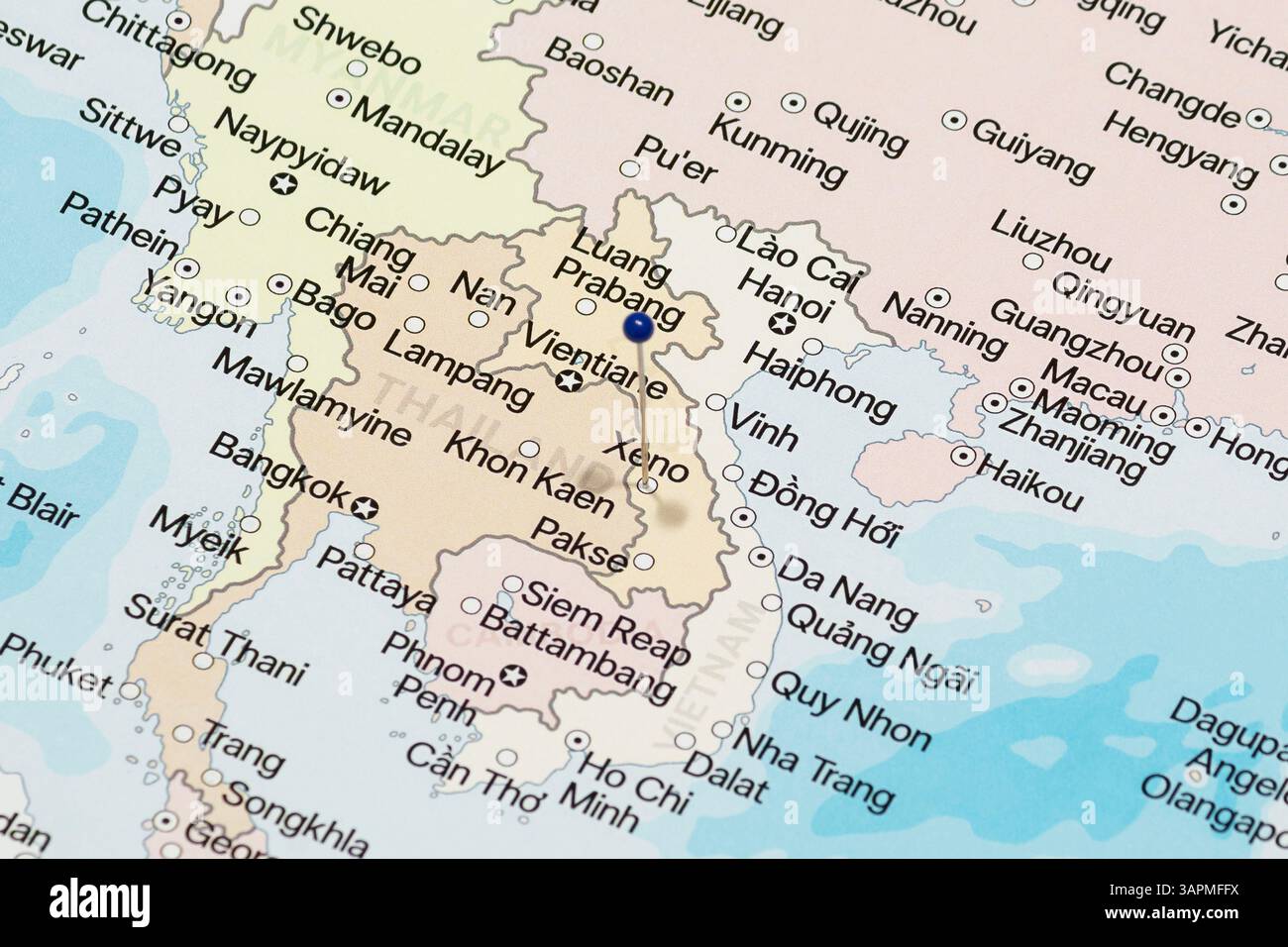macro photo of a blue pin needle into Xeno city of Laos political map ...