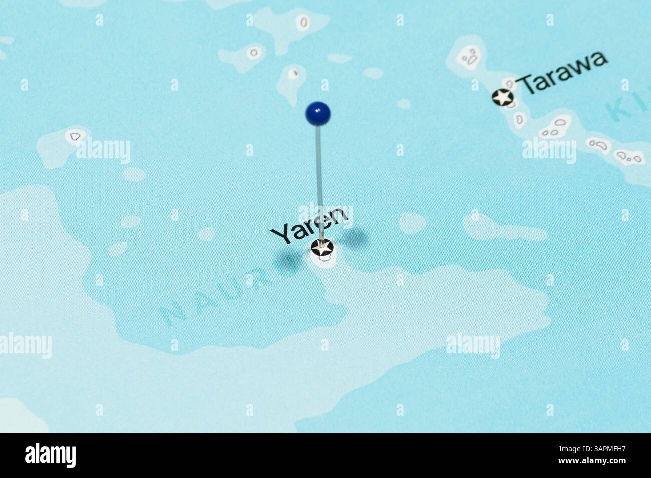 macro photo of a blue pin needle into Yaren city of Nauru political map ...