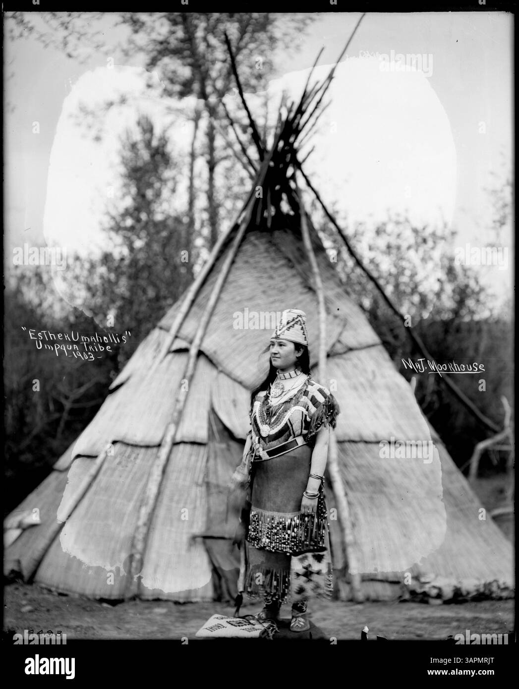 A portrait of Esther Umahollis, an Umpqua tribal woman, in regalia next ...