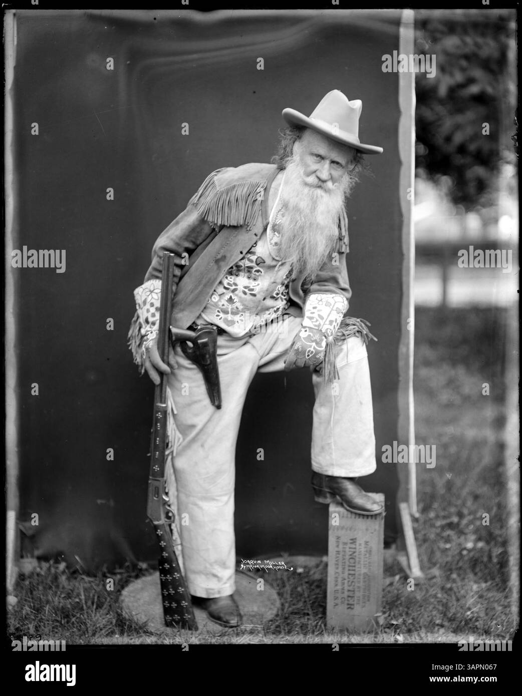 Photograph of Joaquin Miller in frontier costume holding a rifle ...