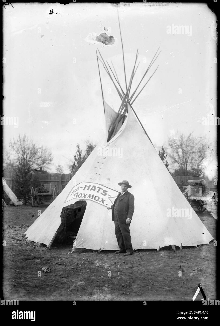 A man is shown standing by a tipi, a traditional Native American ...