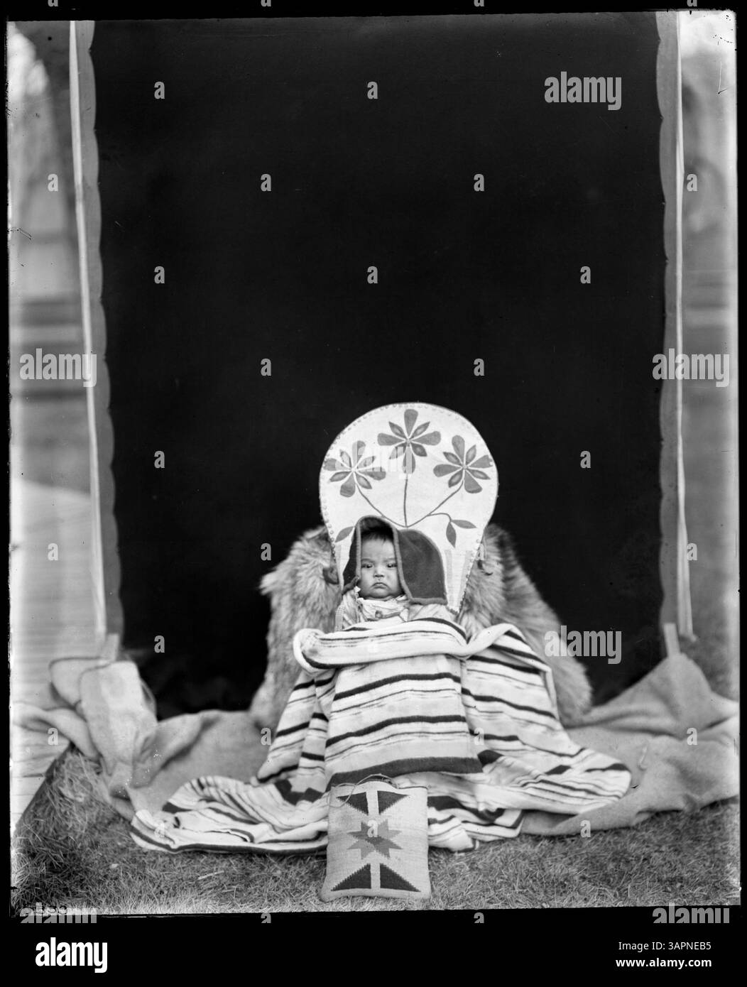 Photograph by Lee Moorhouse of a tribal infant in a cradle, a ...