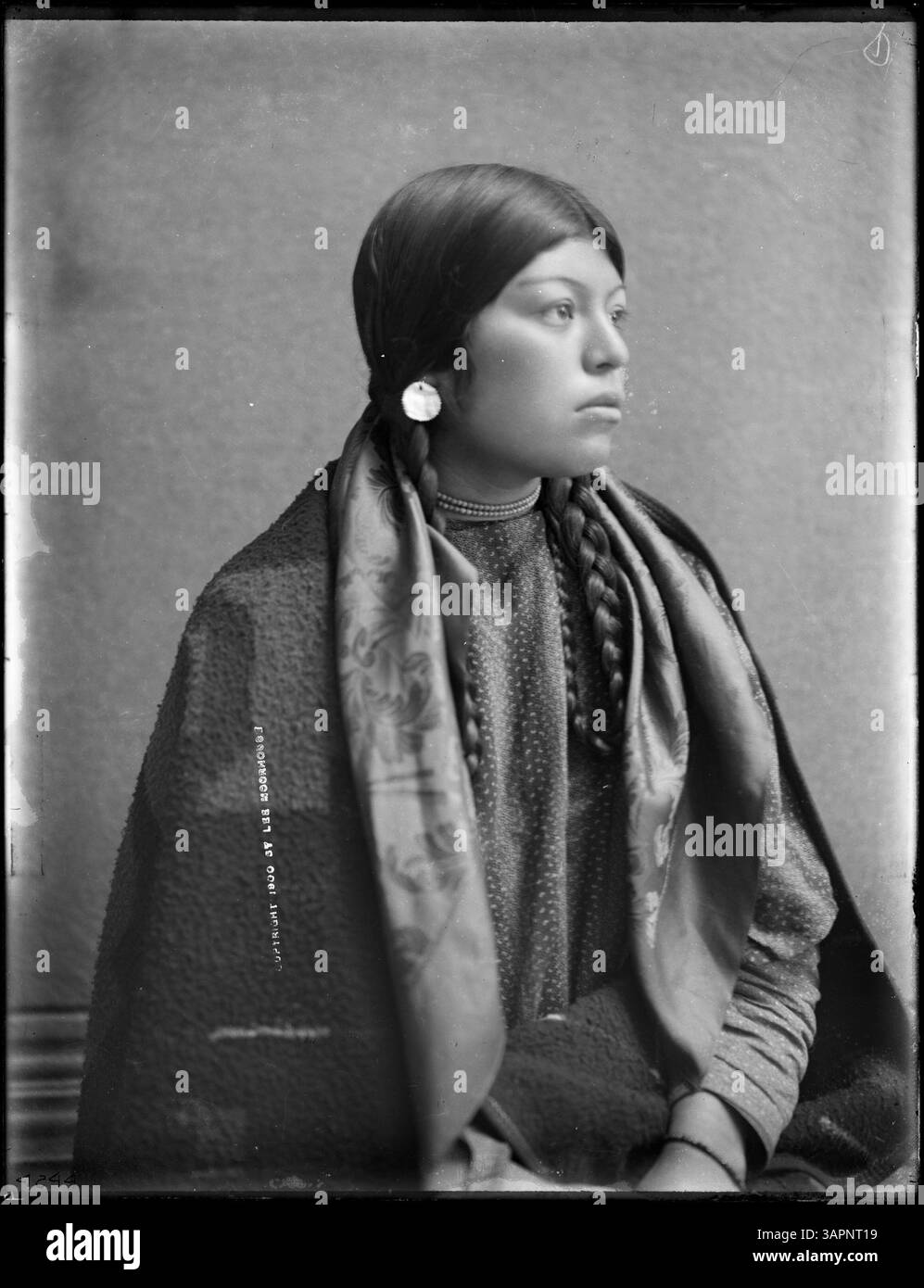 This photograph features Ku-mas-sag, a Cayuse tribal girl, dressed in ...