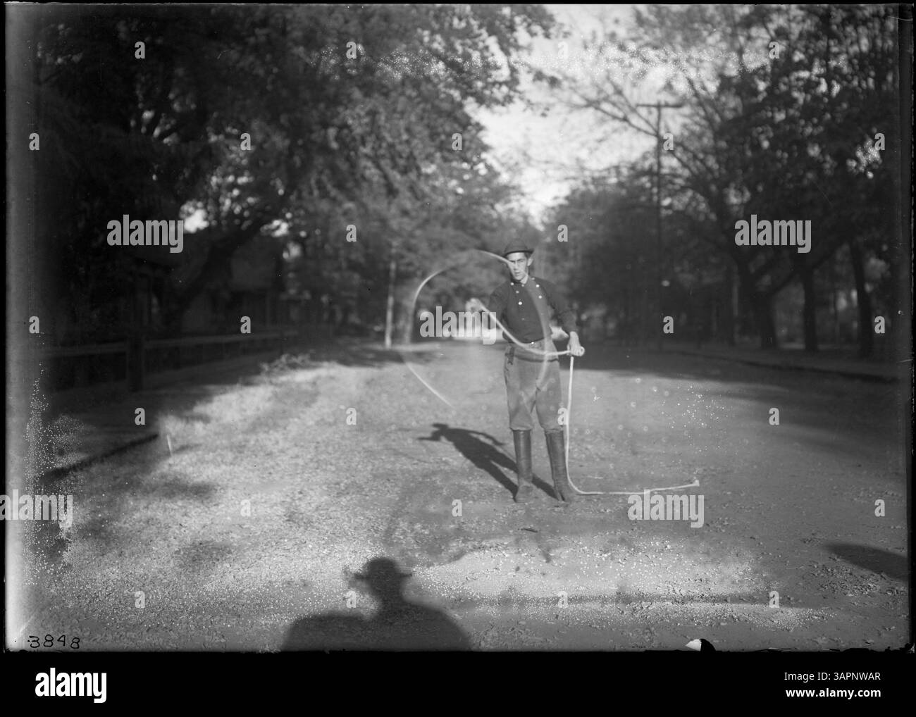 A photograph of L.E. McCoy performing trick roping, capturing a moment ...