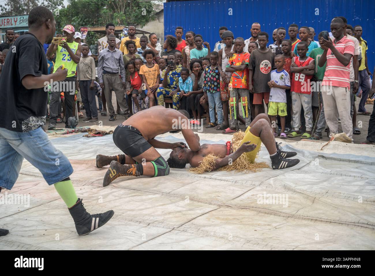 Catch Congolese wrestlers engage in a match on a makeshift ring in the ...