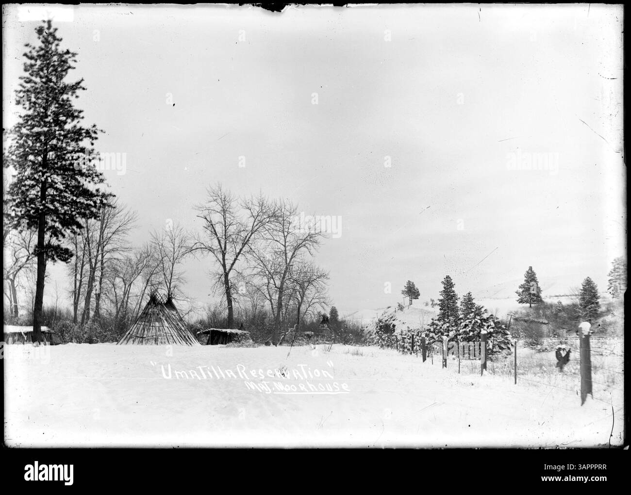 This photograph shows a tribal lodge and a barbed-wire fence on the ...