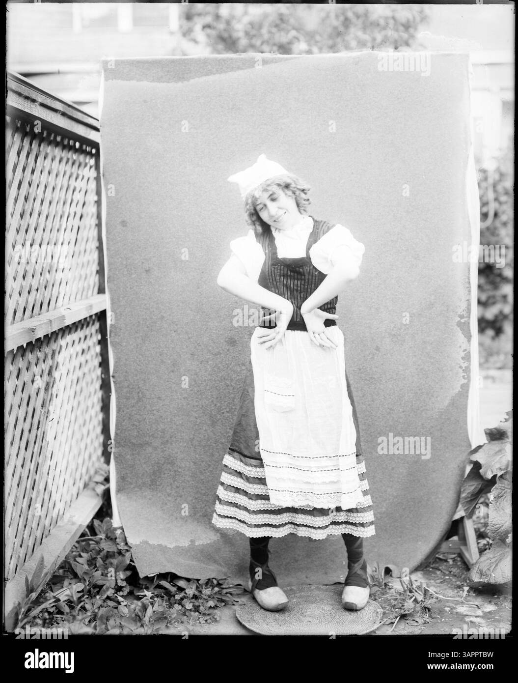 This photograph shows a performer, possibly male, comically posed in ...