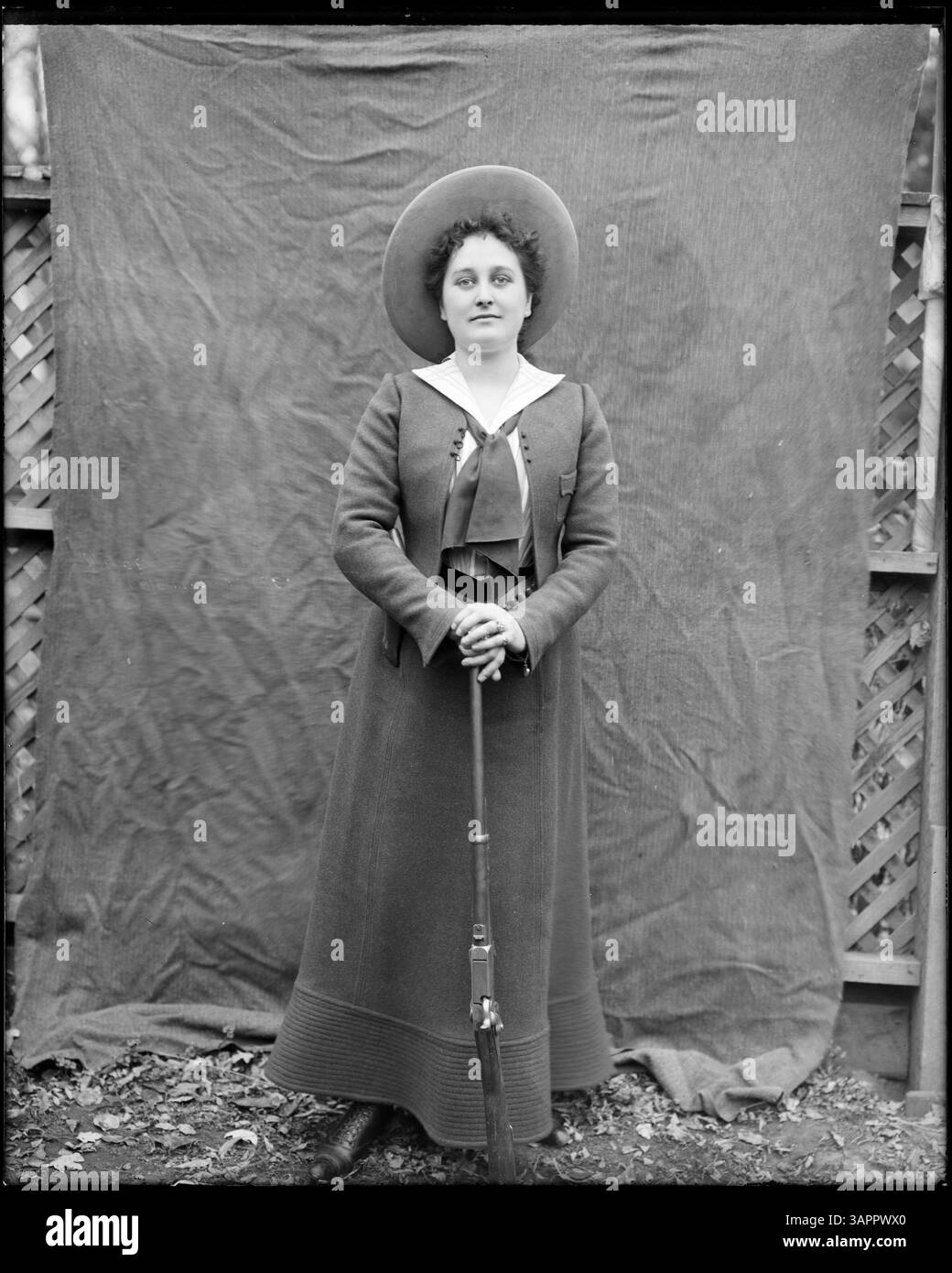 Photograph of Alice Archer in shooting costume holding a rifle, part of ...