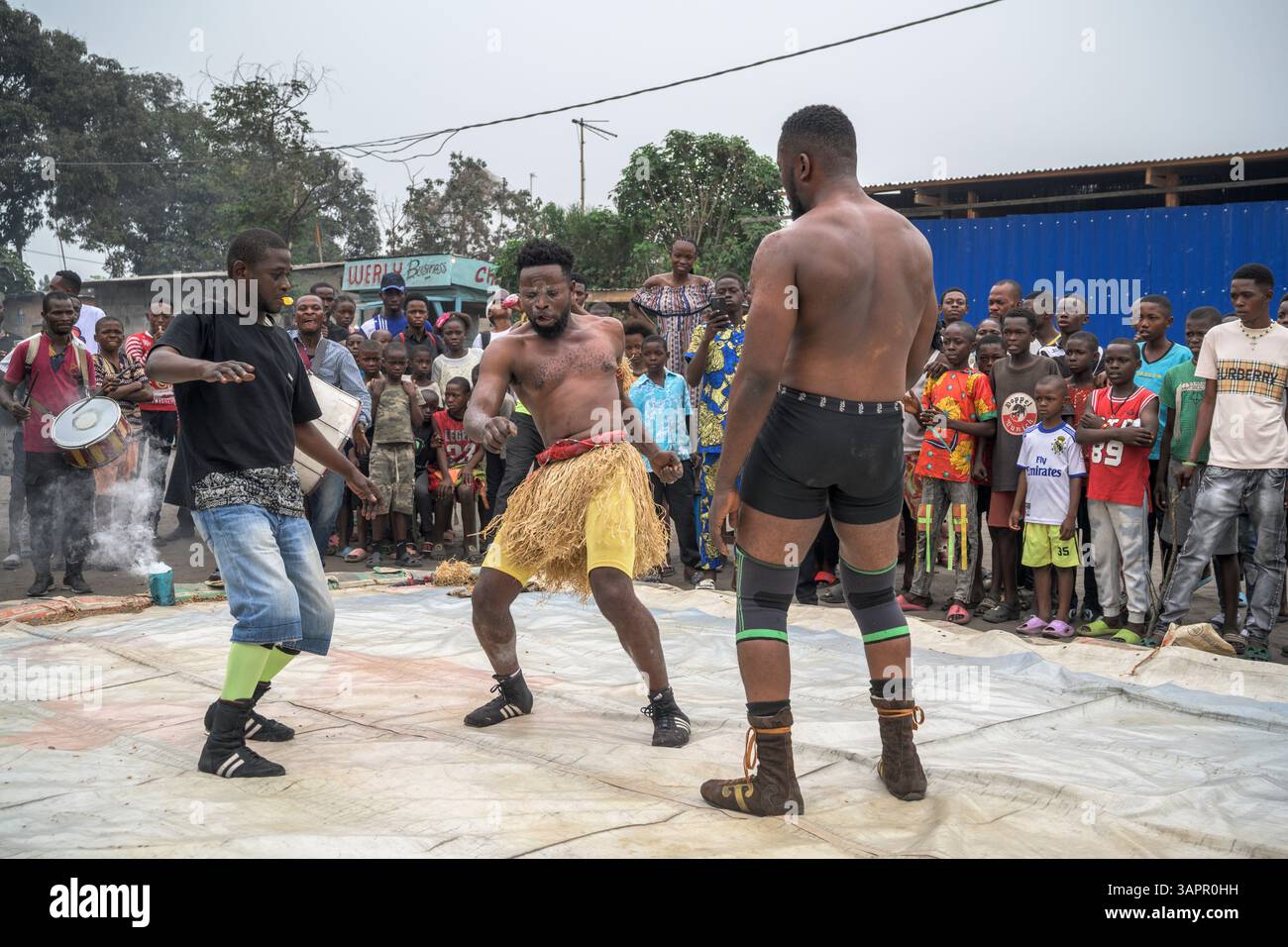 Catch Congolese wrestlers engage in a match on a makeshift ring in the ...