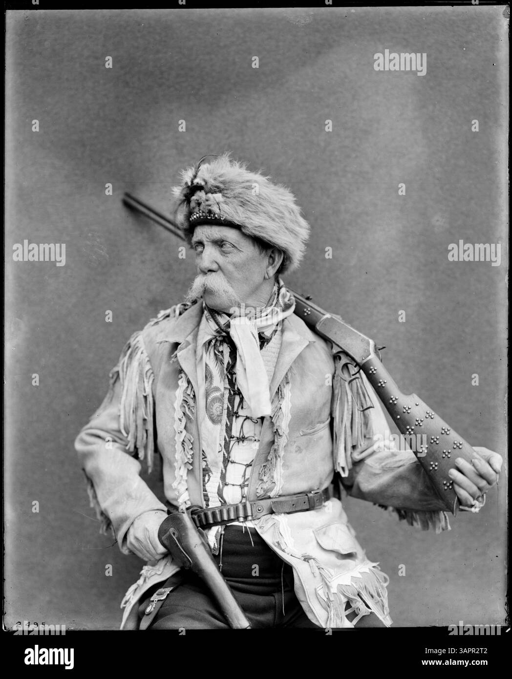 Photograph of Evan S. McComas dressed in a scout costume, holding a ...