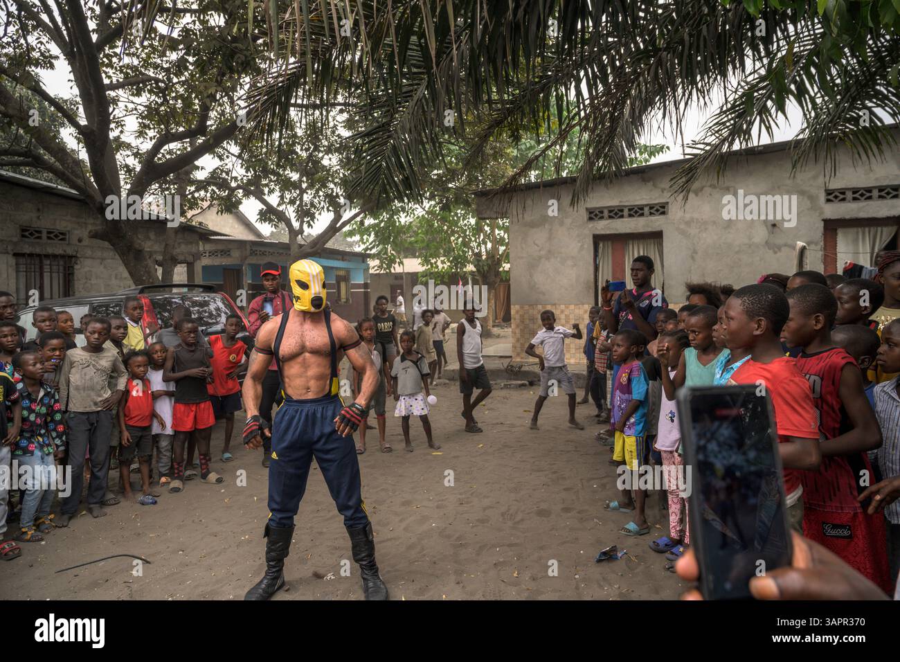 Portrait of a masked Catch Congolese wrestler among the crowd after a ...