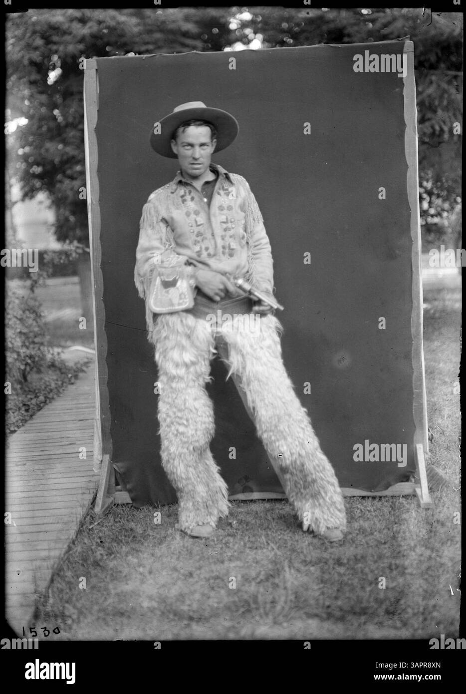 Photograph of Glen Bushee, a cowboy, in a full-length portrait standing ...