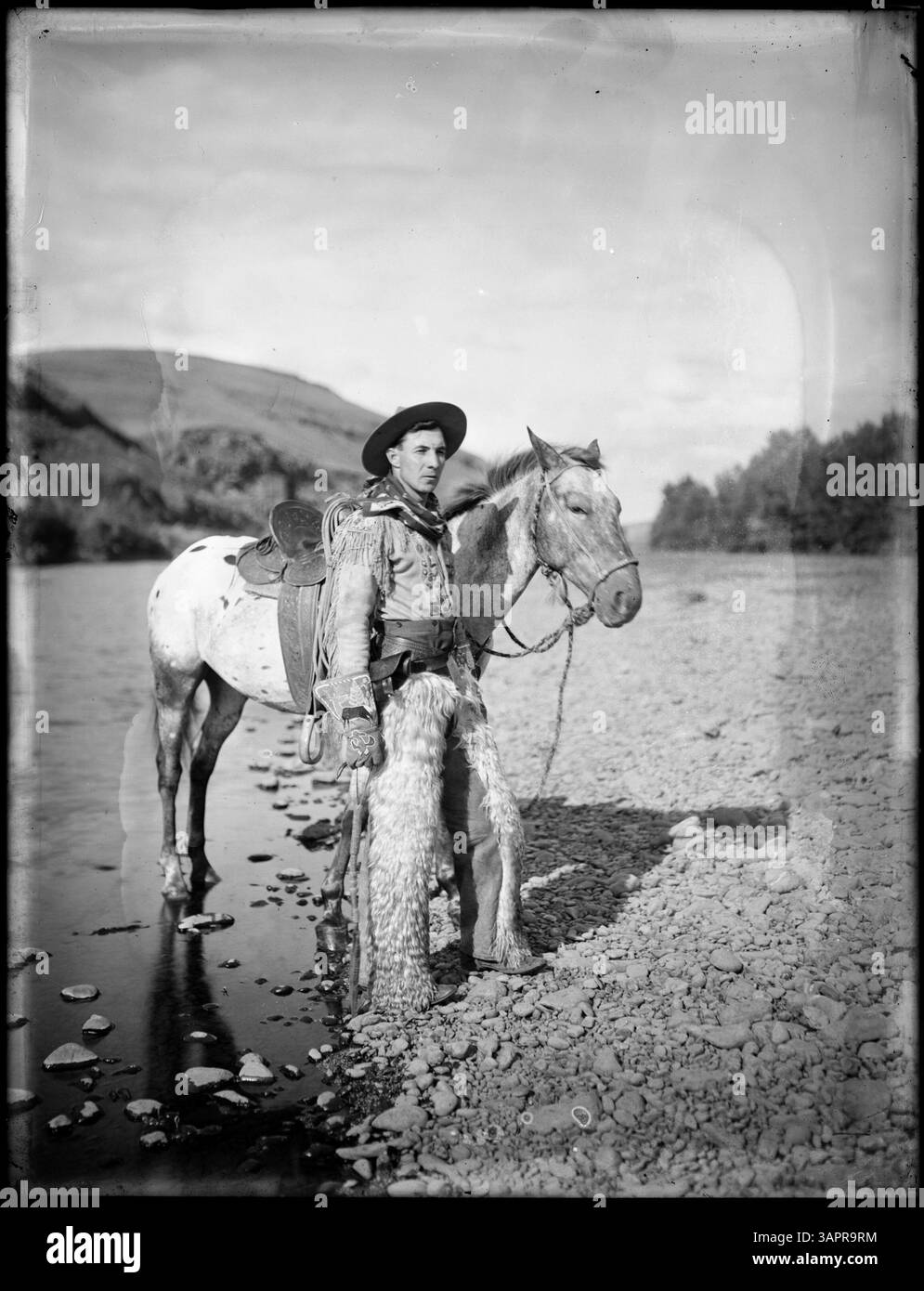 This photograph shows a cowboy in costume with his horse, capturing the ...