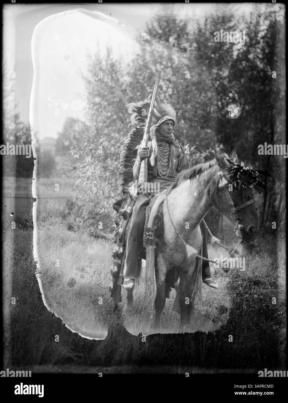 A tribal man in regalia on horseback. The photograph captures the ...