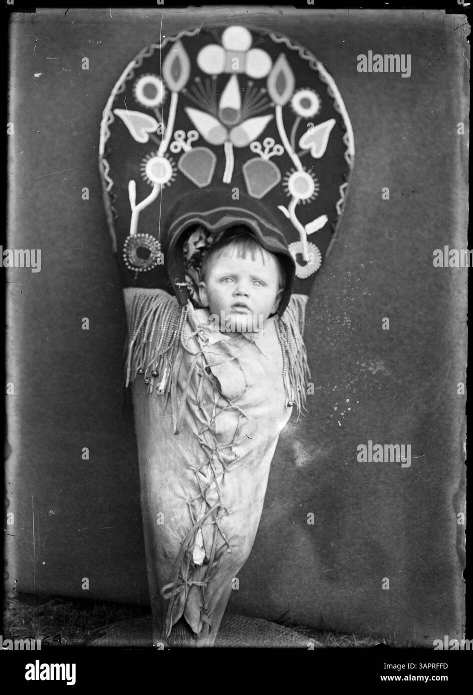 This photograph depicts tribal infants in cradles, a traditional ...