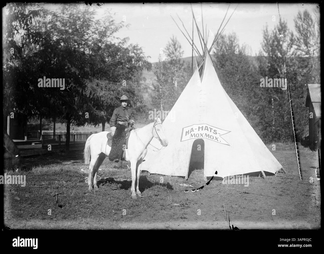 This photograph features a man on horseback with a tipi in the ...
