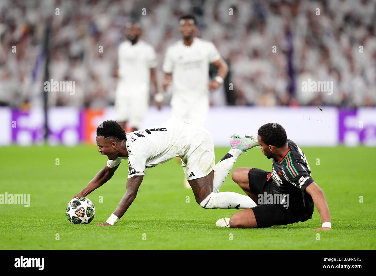 Real Madrid's Vinicius Junior (left) is tackled by Arsenal's Jurrien ...