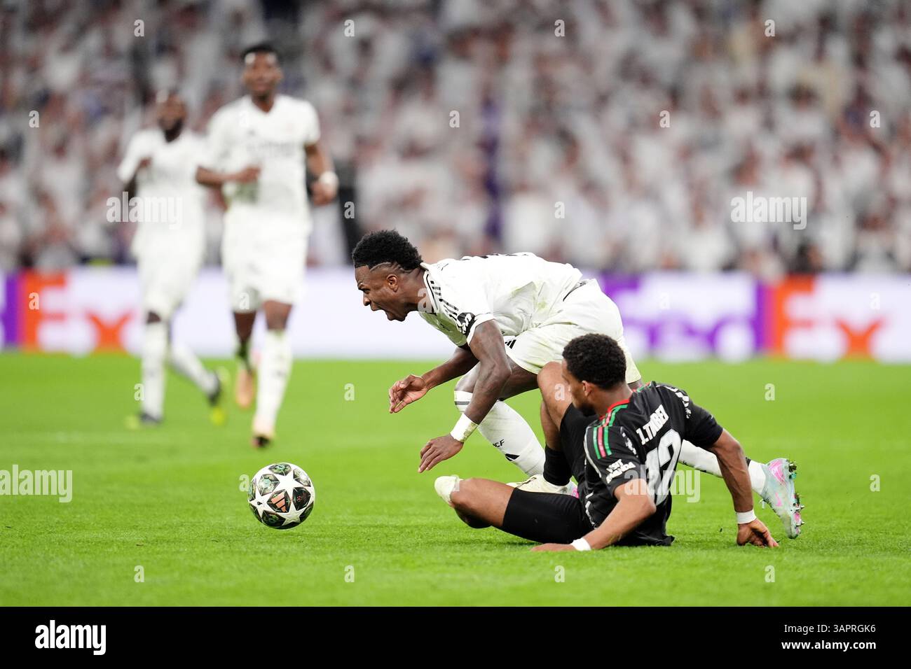 Real Madrid's Vinicius Junior (centre) is tackled by Arsenal's Jurrien ...